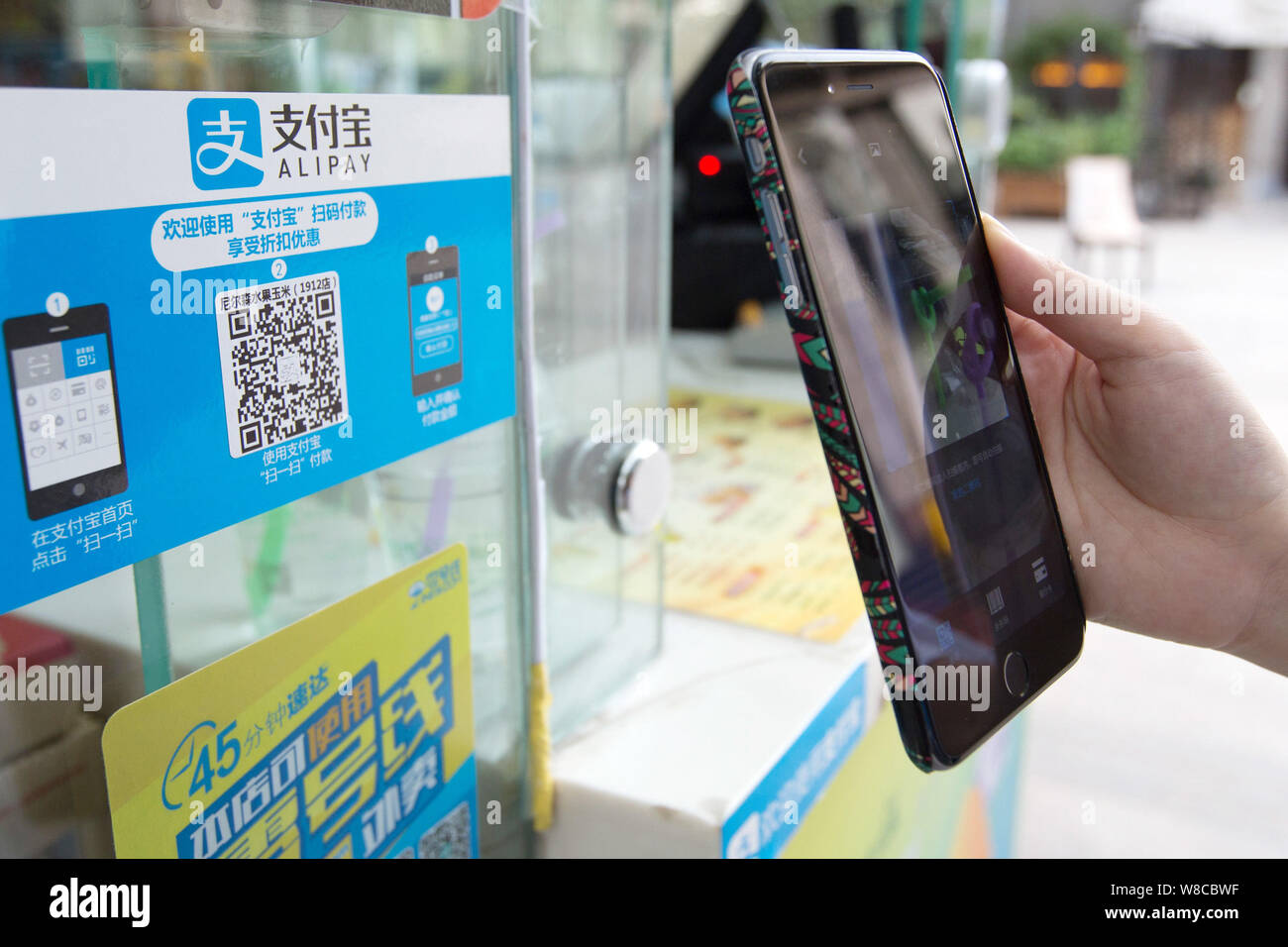 --FILE--A customer uses her smartphone to scan a QR code to pay by ...