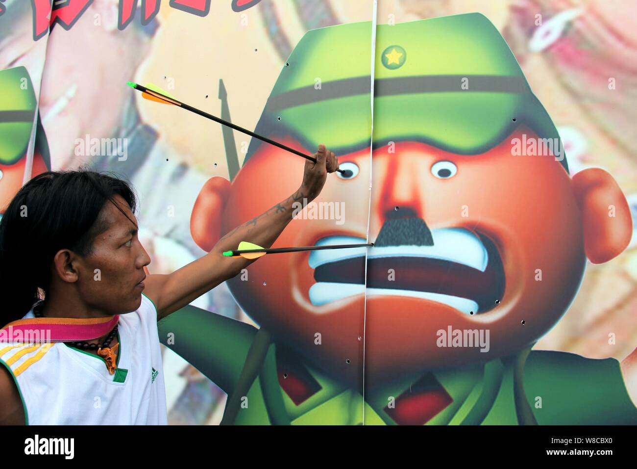 A worker pulls arrows out from a board featuring cartoon images of ...