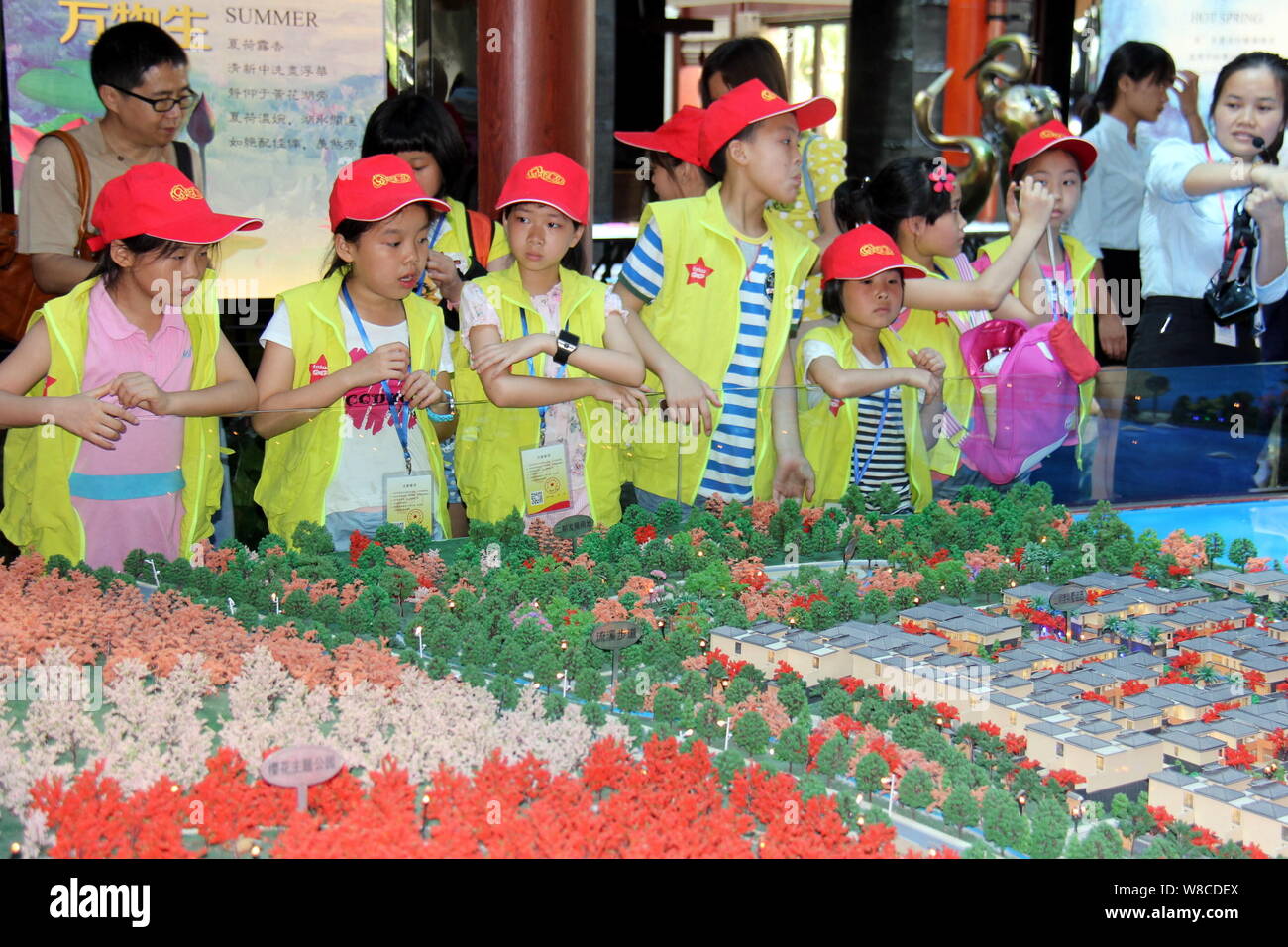 Chinese parents and their children look at models of luxury villas ...