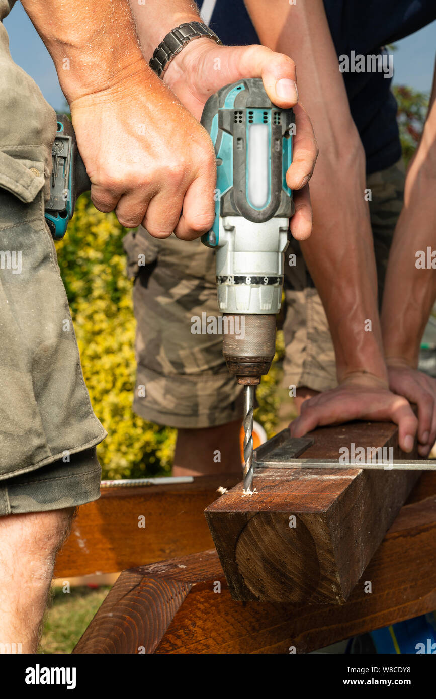 a craftsman drills hole into timber wtih cordless screwdriver Stock ...