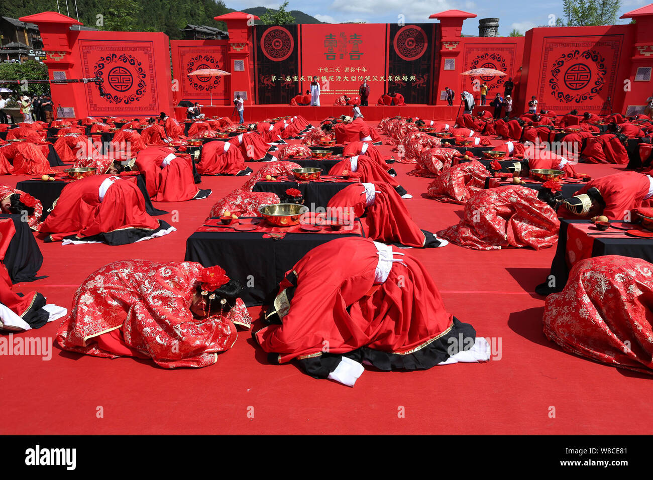 Couples of newlyweds dressed in Chinese Han costumes bow to each other ...