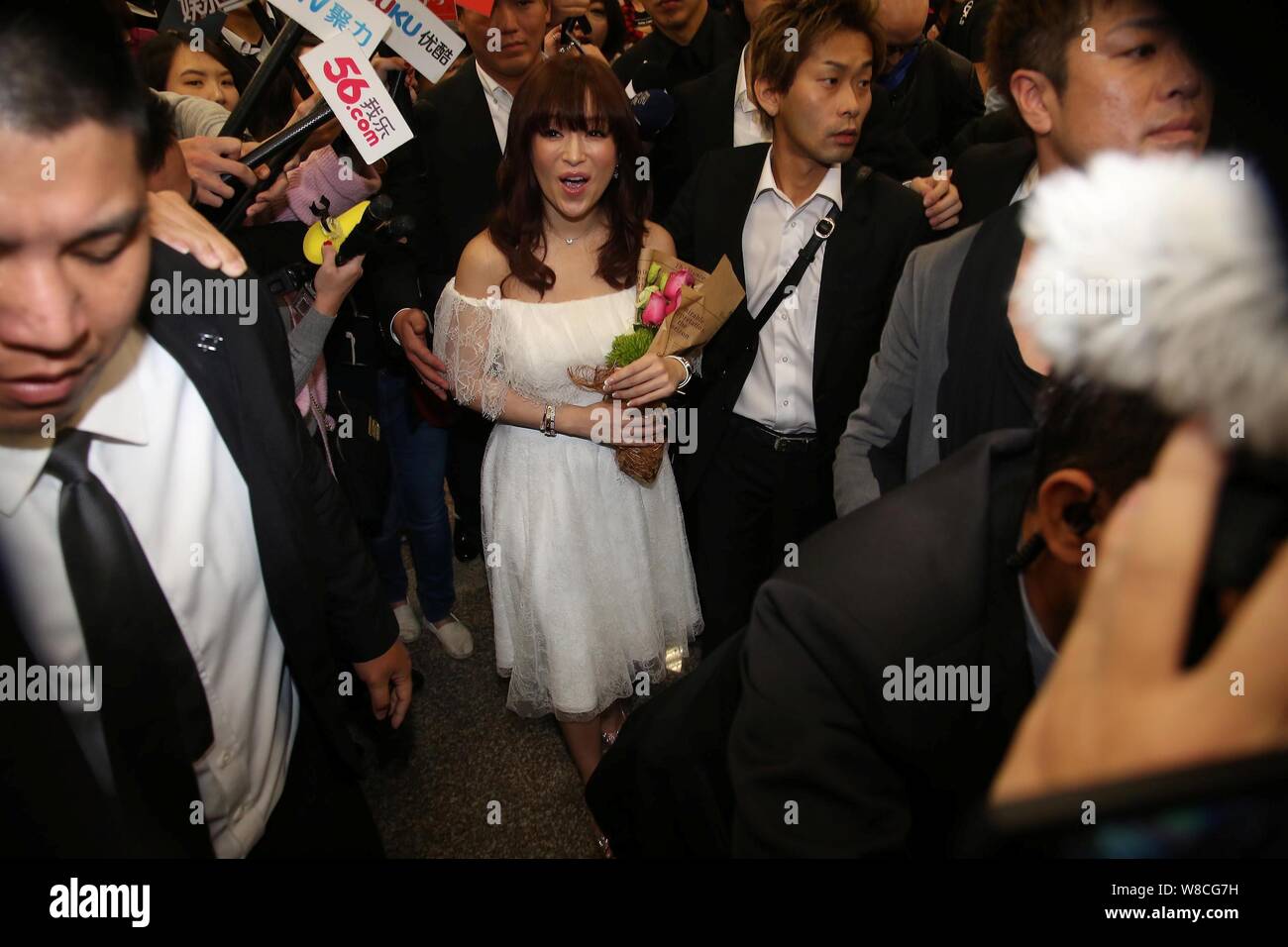 Japanese singer Ayumi Hamasaki, center, is surrounded by reporters at the Taipei Songshan ...