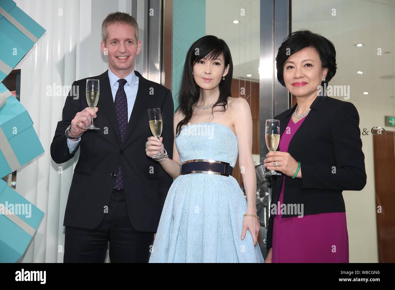 Hong Kong singer Vivian Chow, center, poses with executives during the ...