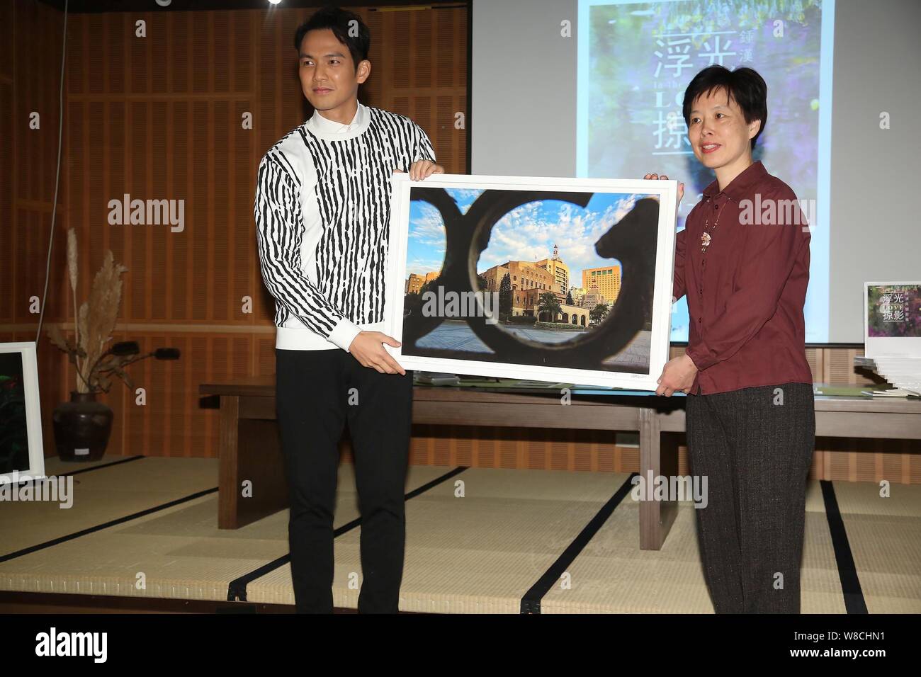 Hong Kong actor Wallace Chung, left, displays a photo with a guest ...
