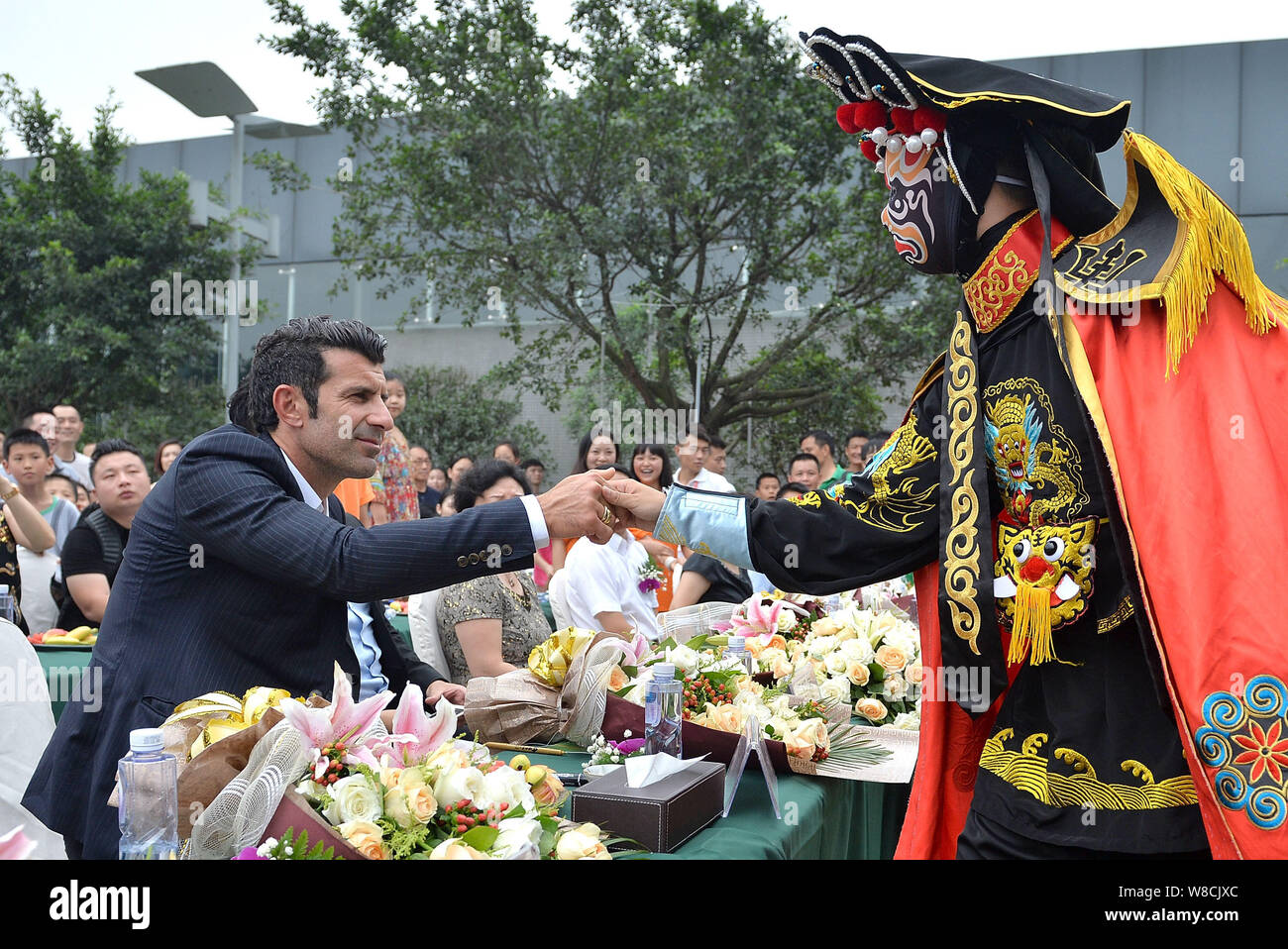 Portuguese football star Luis Figo, left, shakes hands with an ...
