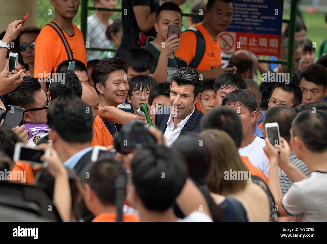 Portuguese football star Luis Figo, center, is surrounded by Chinese ...