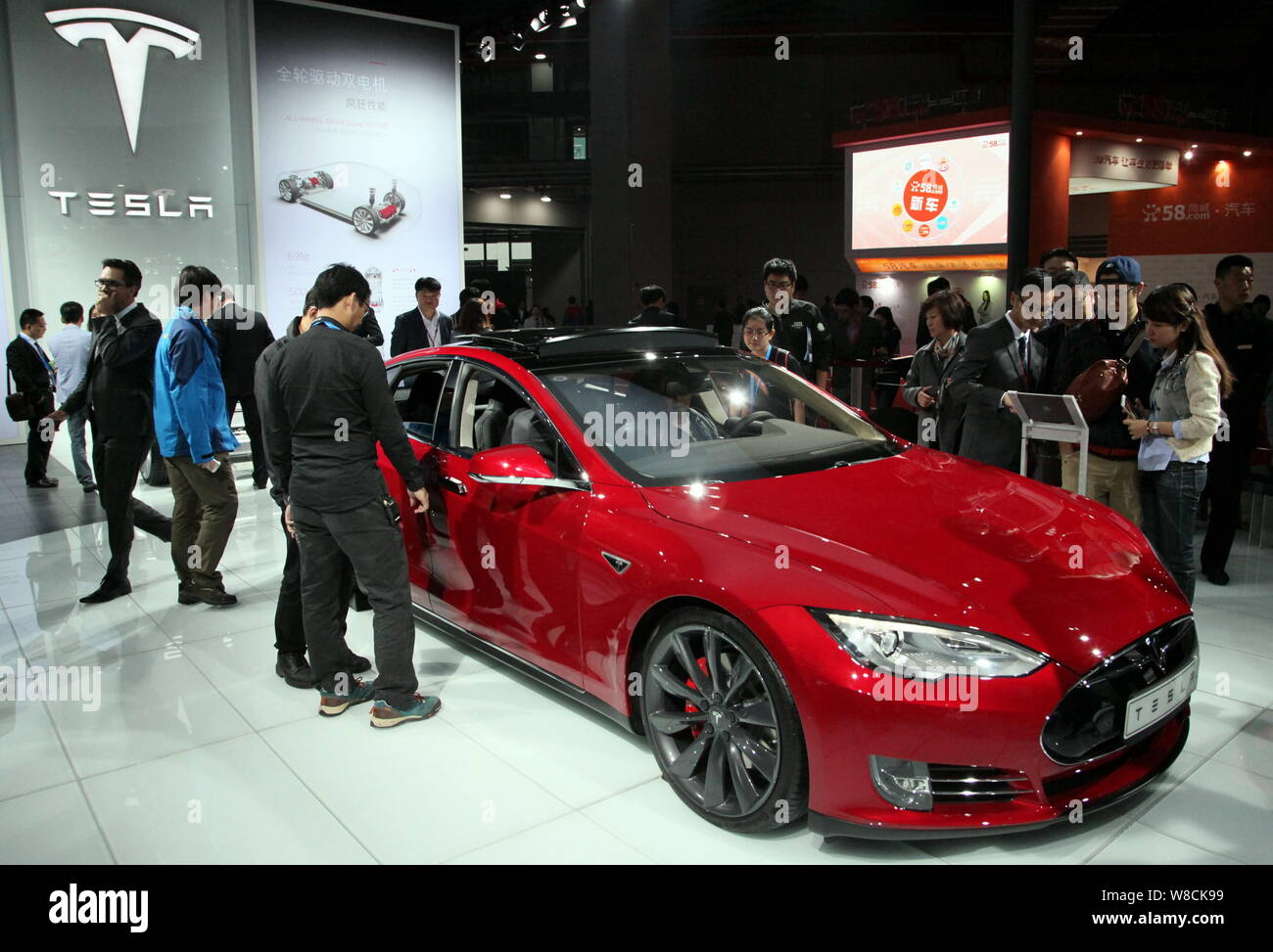 Visitors look at a Tesla Model S electric car during the 16th Shanghai ...