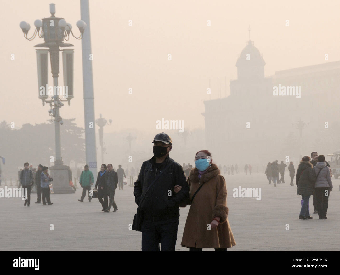 Tourists wearing face masks against air pollution visit the Tiananmen ...
