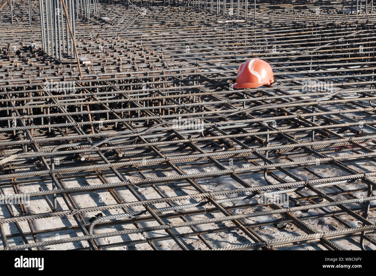 Orange hardhat on the steel grid of residential building footing ...