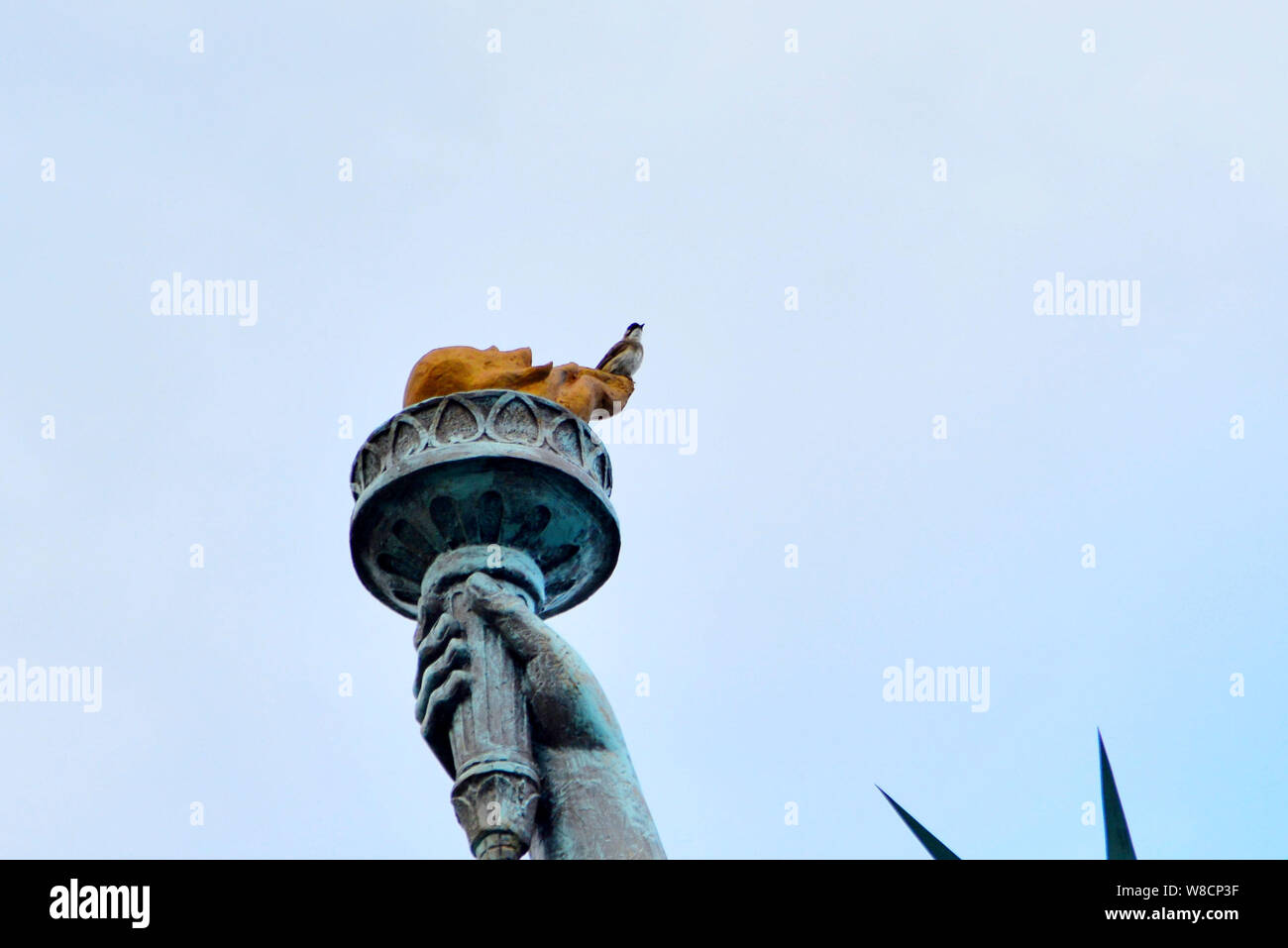 A bird stands atop a downsized replica of the Statue of Liberty in the ...