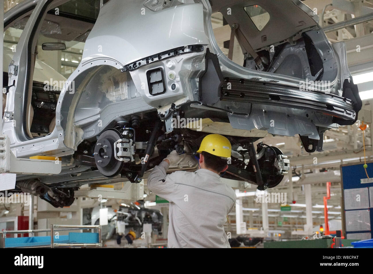 --FILE--A Chinese worker assembles a car on the assembly line at an ...