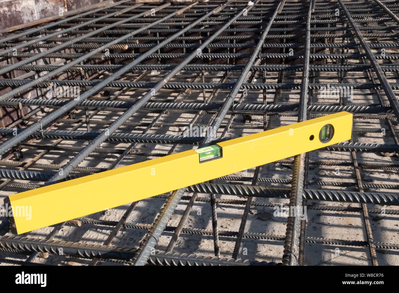 Building yellow colored level tool on the steel grid of residential ...
