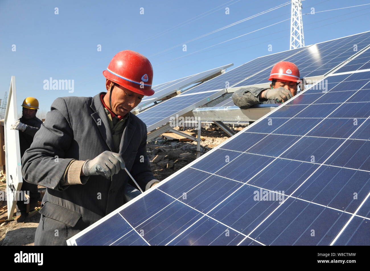 --FILE--Chinese workers install solar panels at a photovoltaic (PV ...