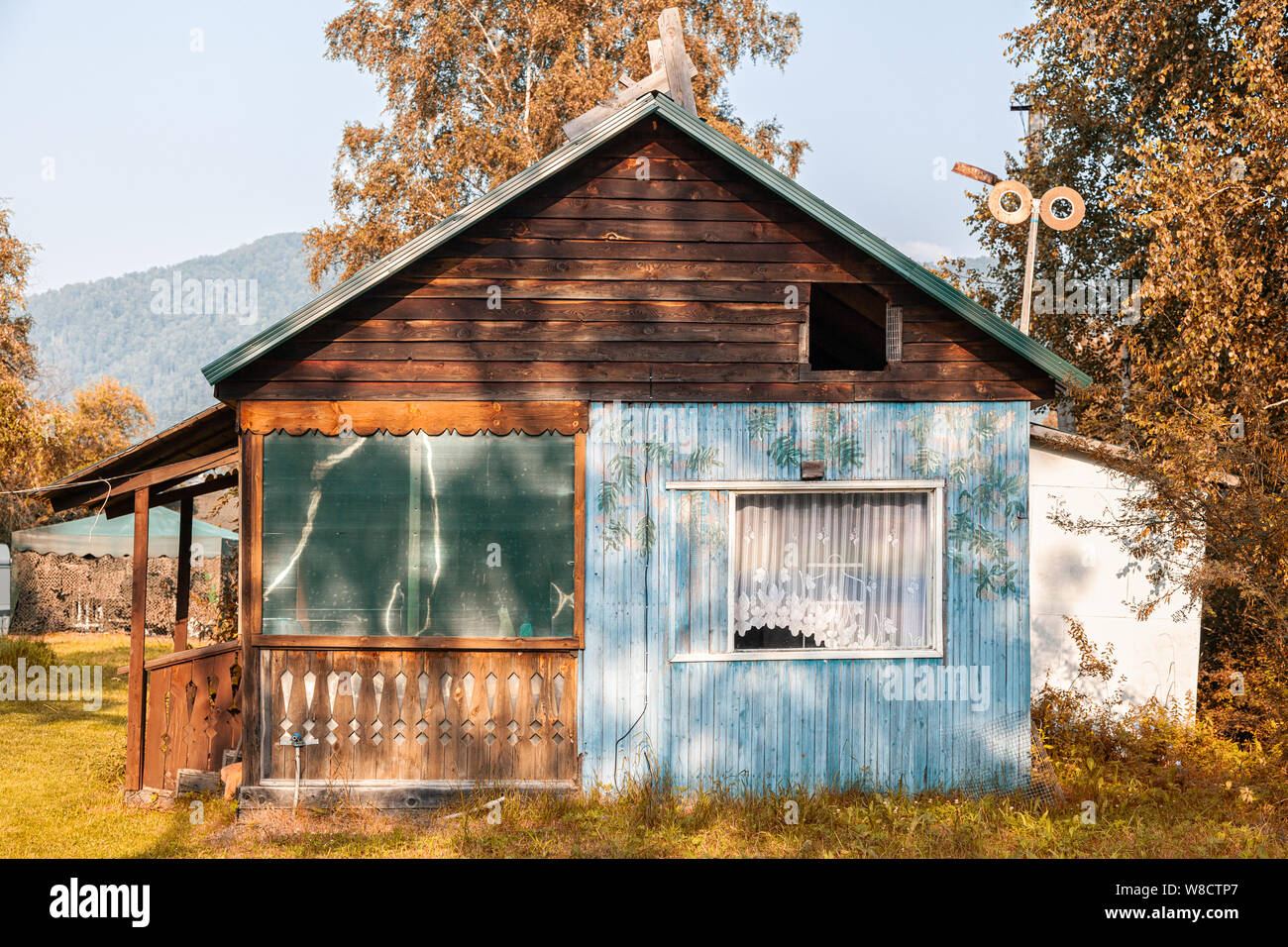 Close-up of a summer wooden house with a small veranda, a wooden window ...