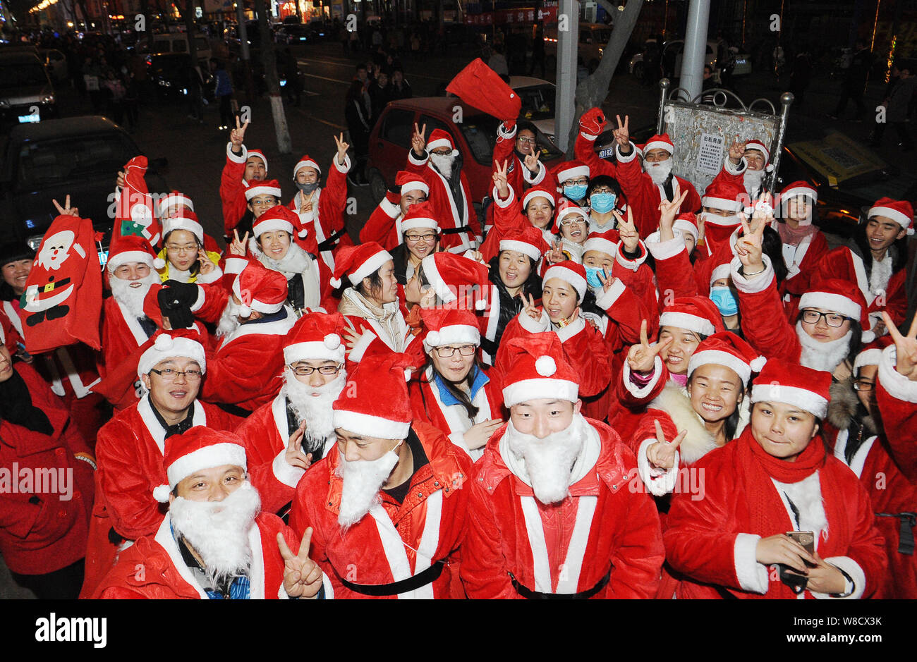 Entertainers dressed in Santa Claus costumes take part in a parade to ...