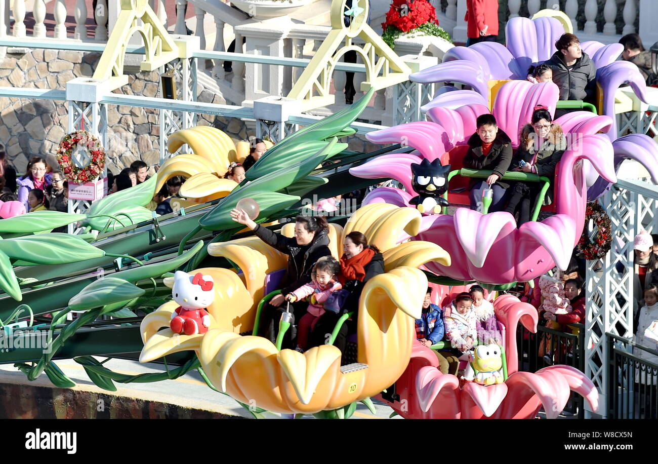 Visitors have fun on an amusement machine at the Hello Kitty theme park ...