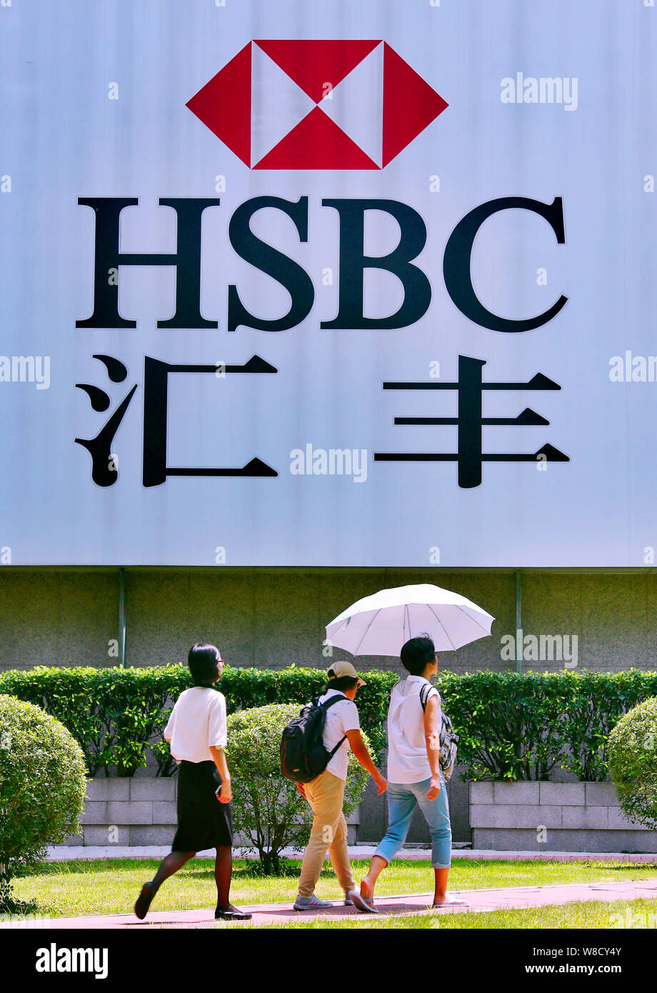 --FILE--Pedestrians walk past an advertisement of HSBC in Guangzhou ...