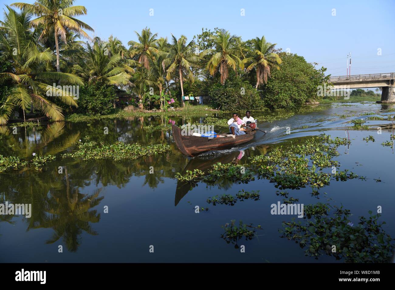 Kerala backwaters. local people on small boat in backwater canals in ...