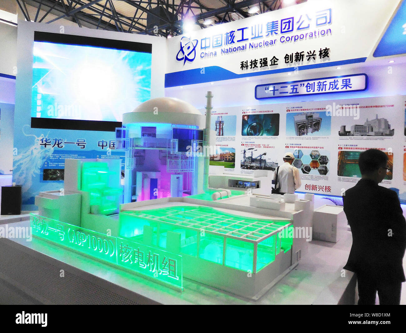 --FILE--A Chinese employee stands next to a model of the Hualong-1 ...