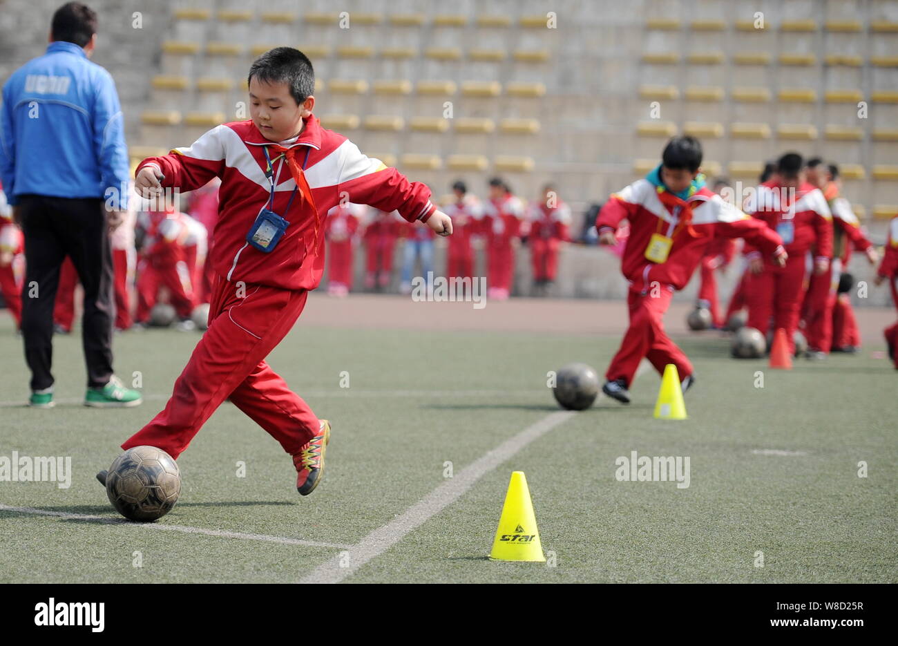 Young Chinese students practice football skills during a training ...