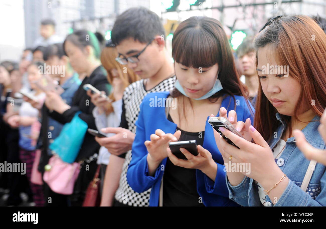 --FILE--Young Chinese people use their smartphones at a shopping mall ...