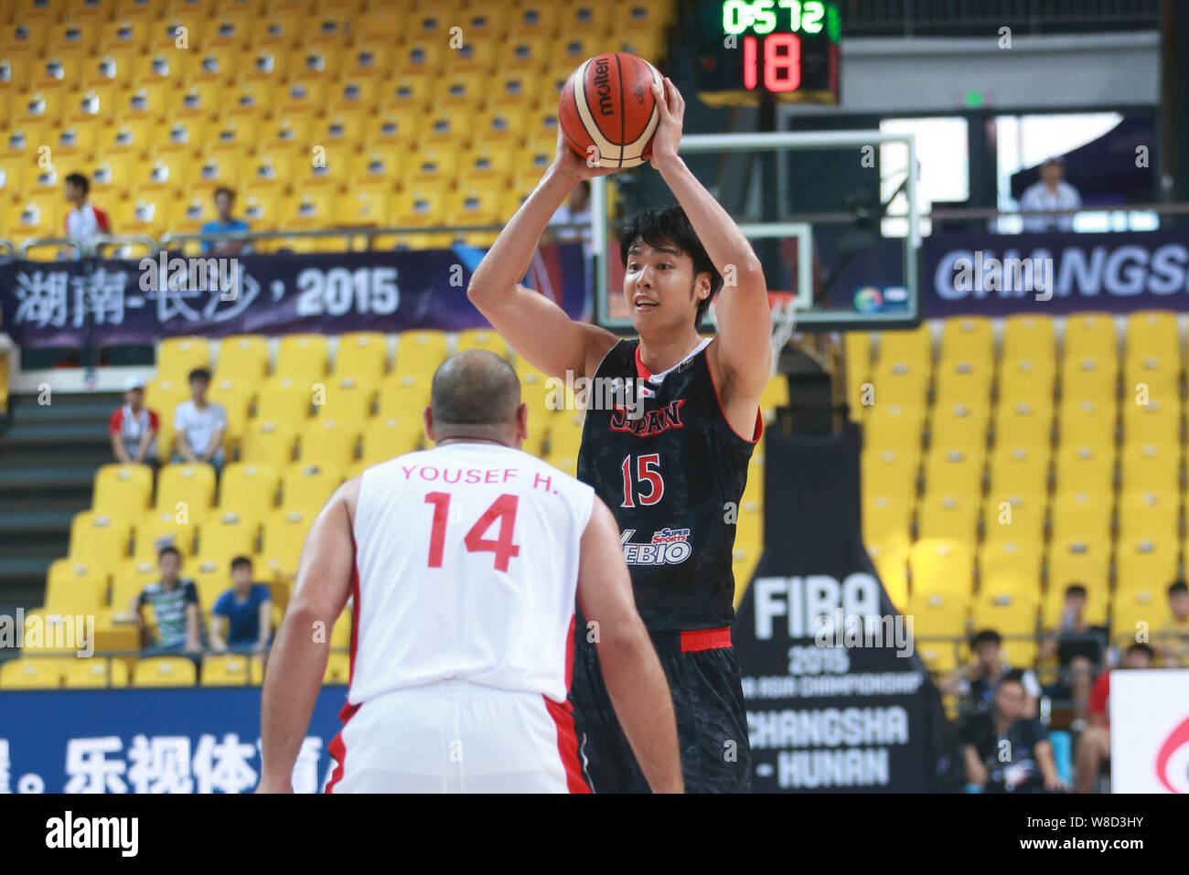 Joji Takeuchi of Japan, back, passes the ball against Hamza Yousef of ...