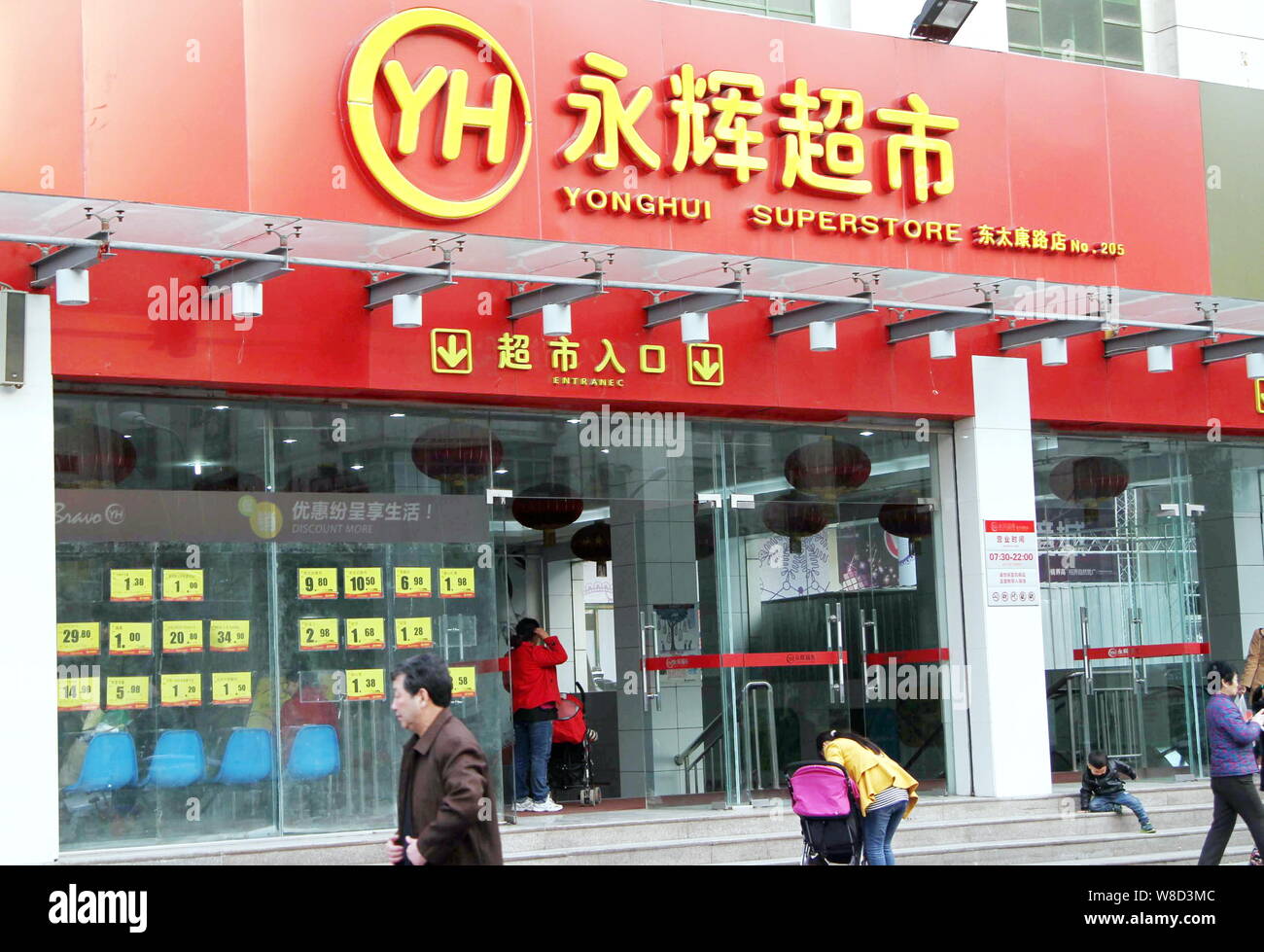 --FILE--Pedestrians walk past a Yonghui (YH) superstore in Zhengzhou ...