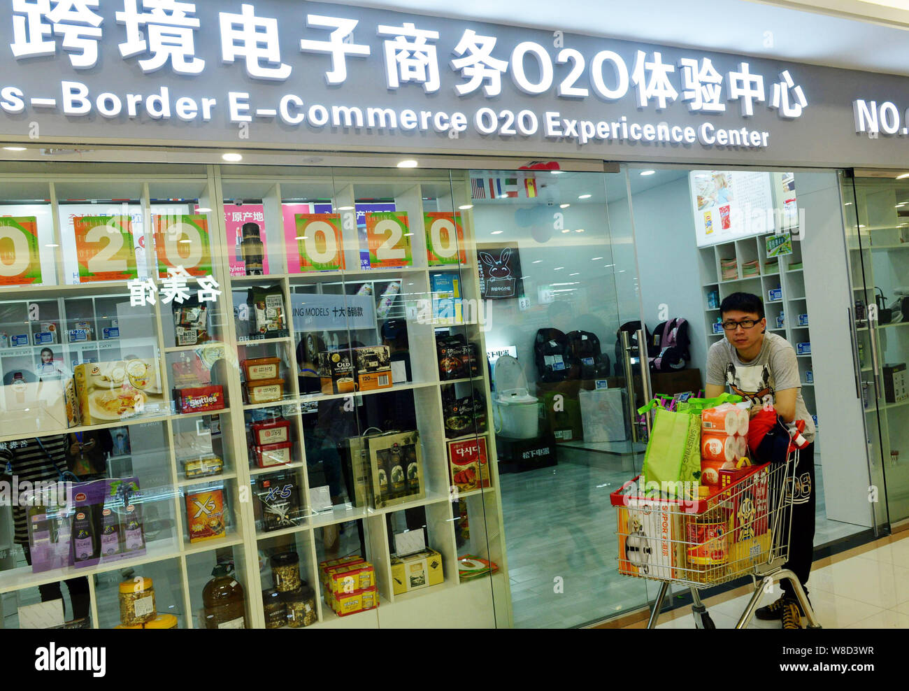 --FILE--A customer pushes a full shopping cart in front of a cross ...
