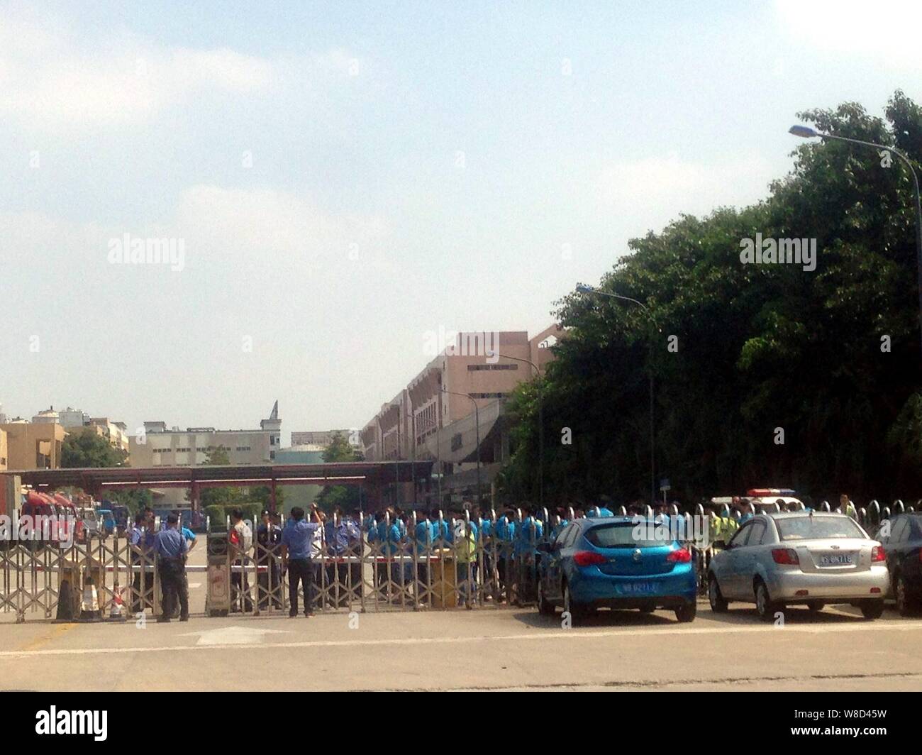 Chinese workers crowd at the entrance of the factory of Kinpo ...
