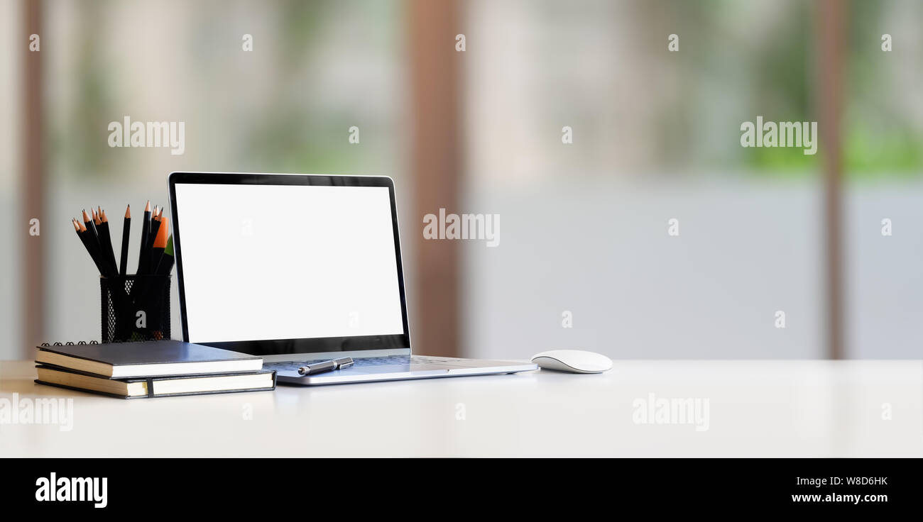 Minimal comfortable work place with blank screen laptop and office ...