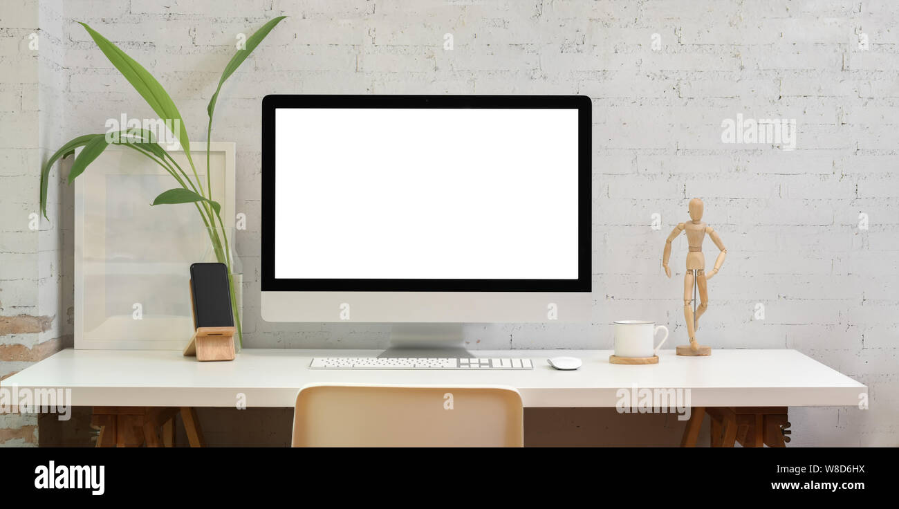 Contemporary workplace with blank screen desktop computer and office ...