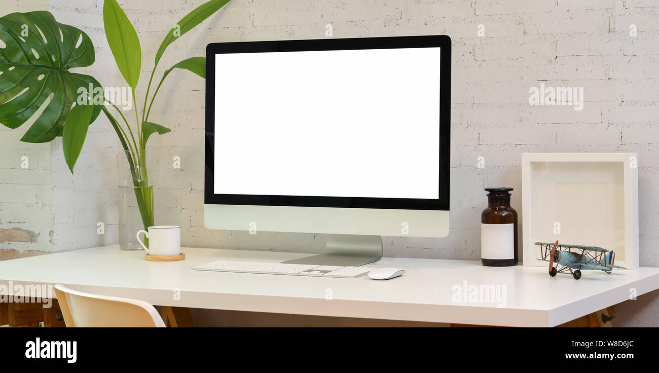 Stylish workplace with blank screen desktop computer with mock up frame ...