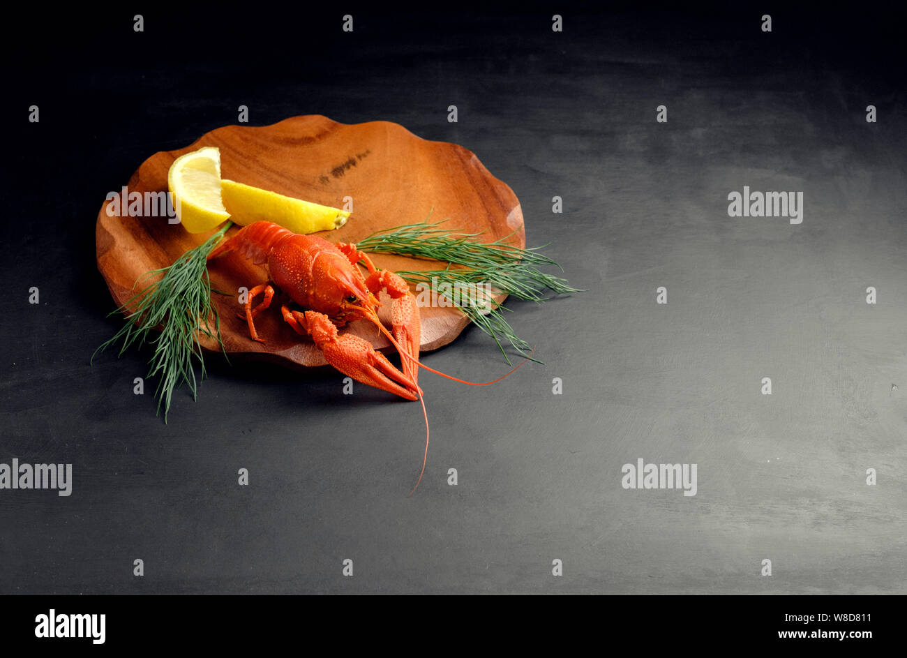 lobster with lemon lime and green dill on board black background top ...