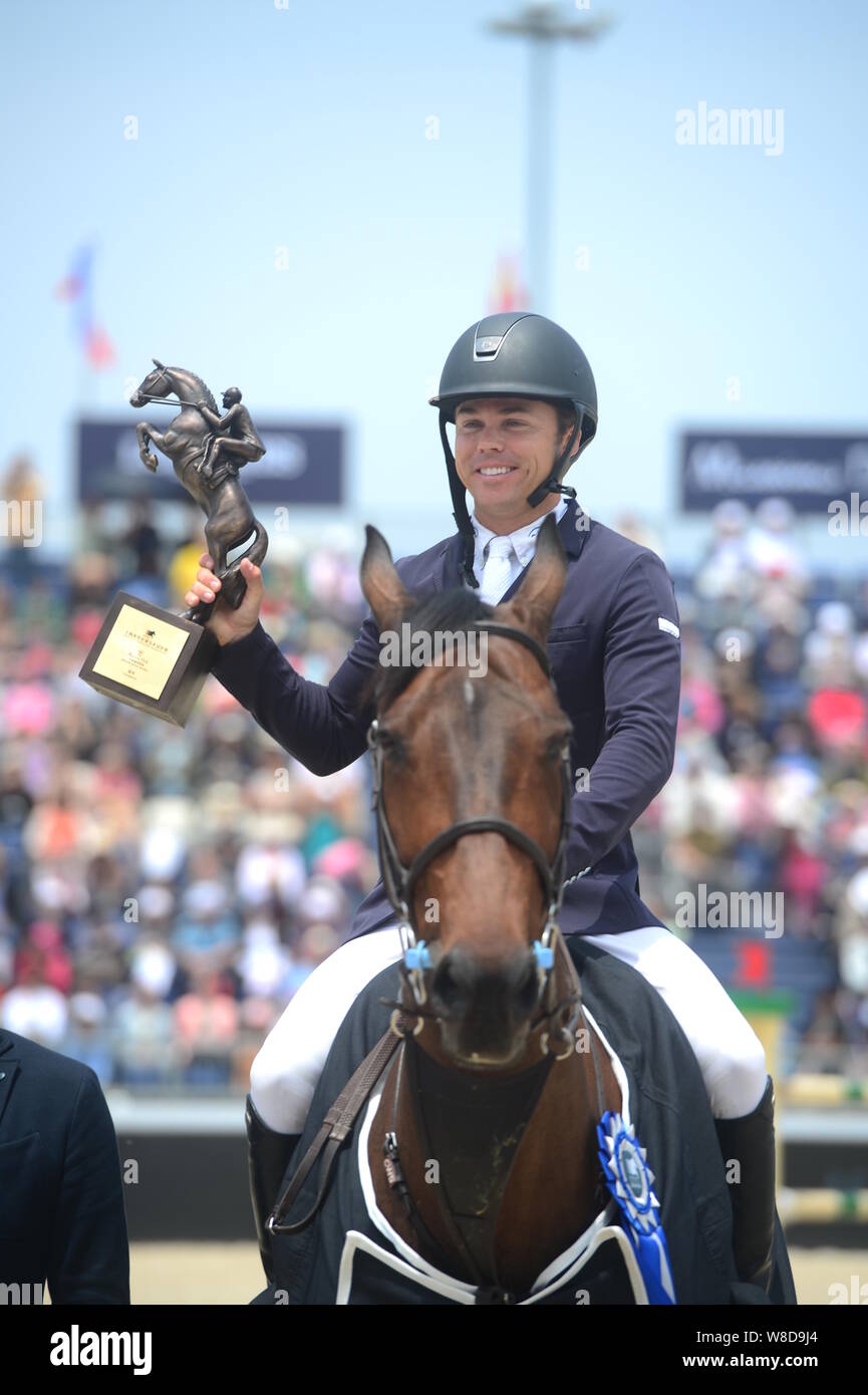 American equestrian rider Kent Farrington poses with his trophy after ...