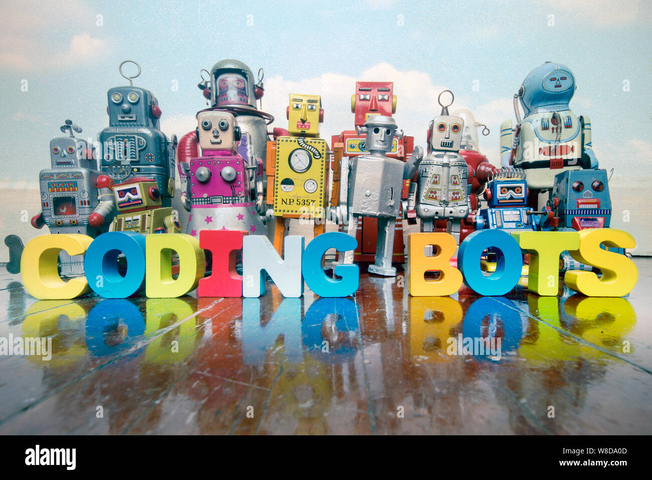 a team of vintage robots on a old wooden floor with the word CODING BOTS toned Stock Photo - Alamy