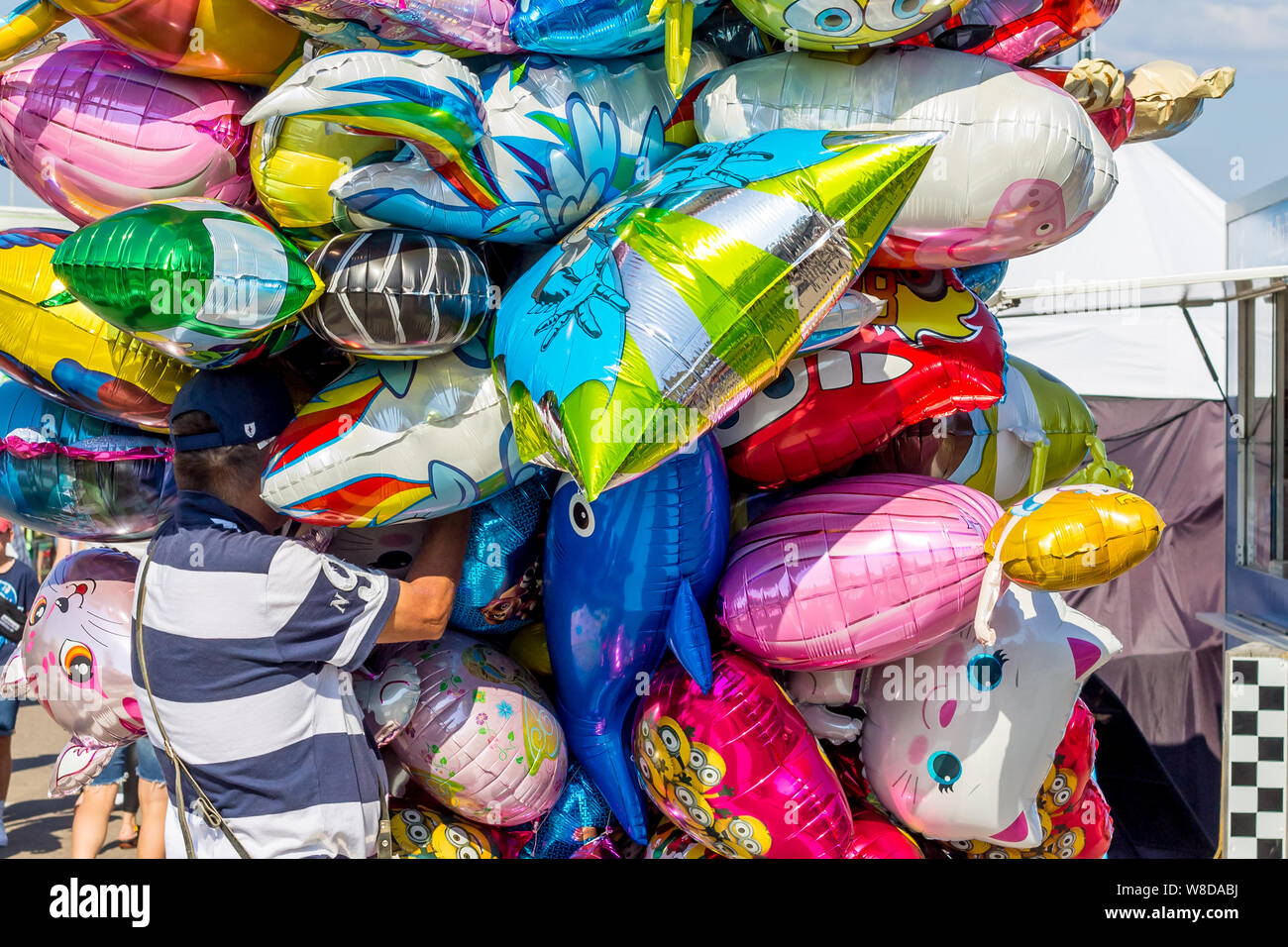 Street salesman buried in his colorful party character balloons Stock ...