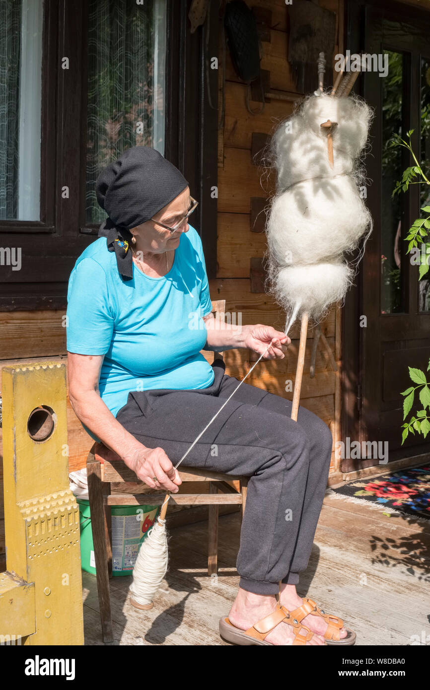 A woman spinning sheep's wool by hand in the village of Botiza ...