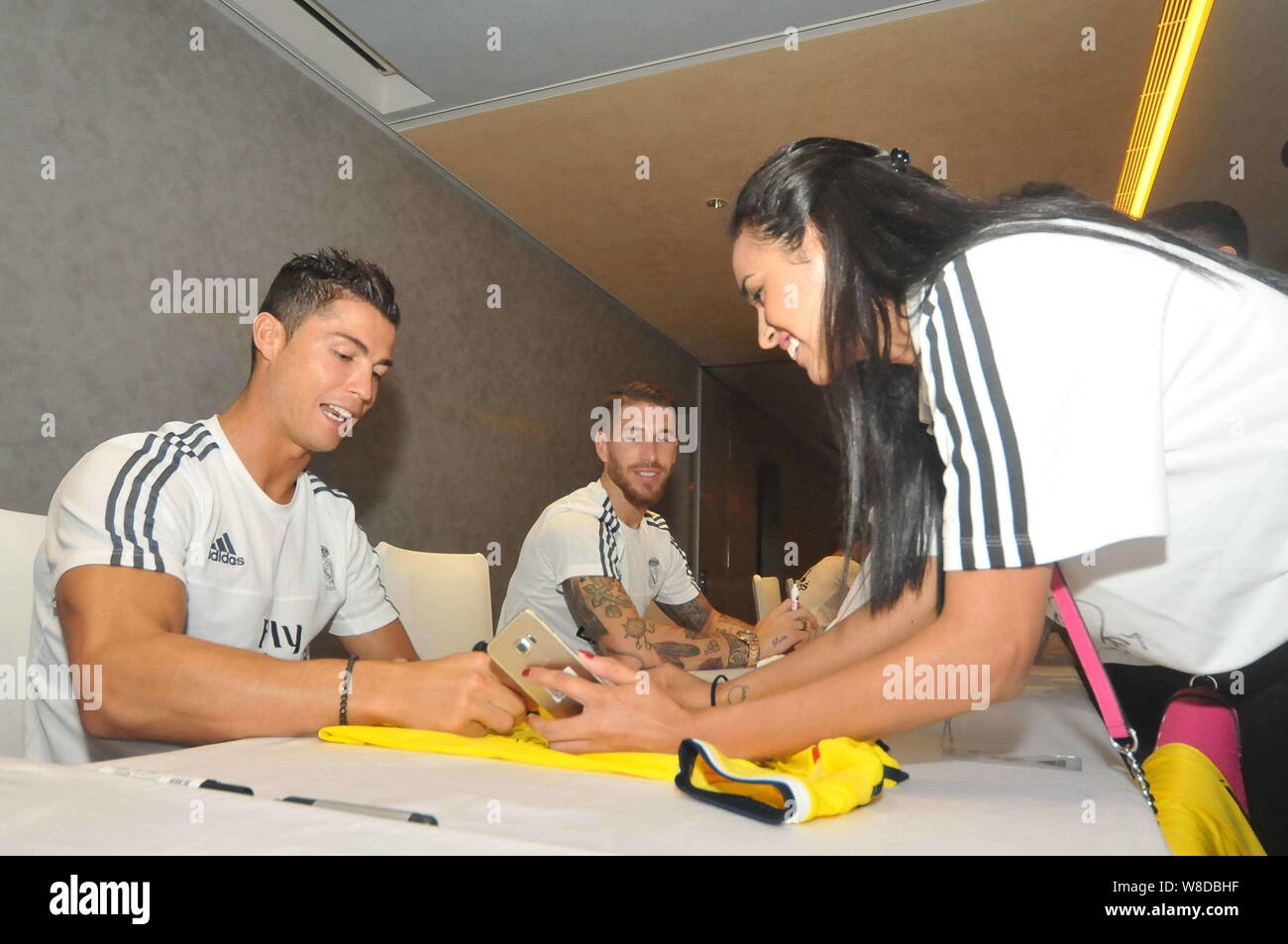 Cristiano Ronaldo of Real Madrid, left, signs an autograph for a fan at ...