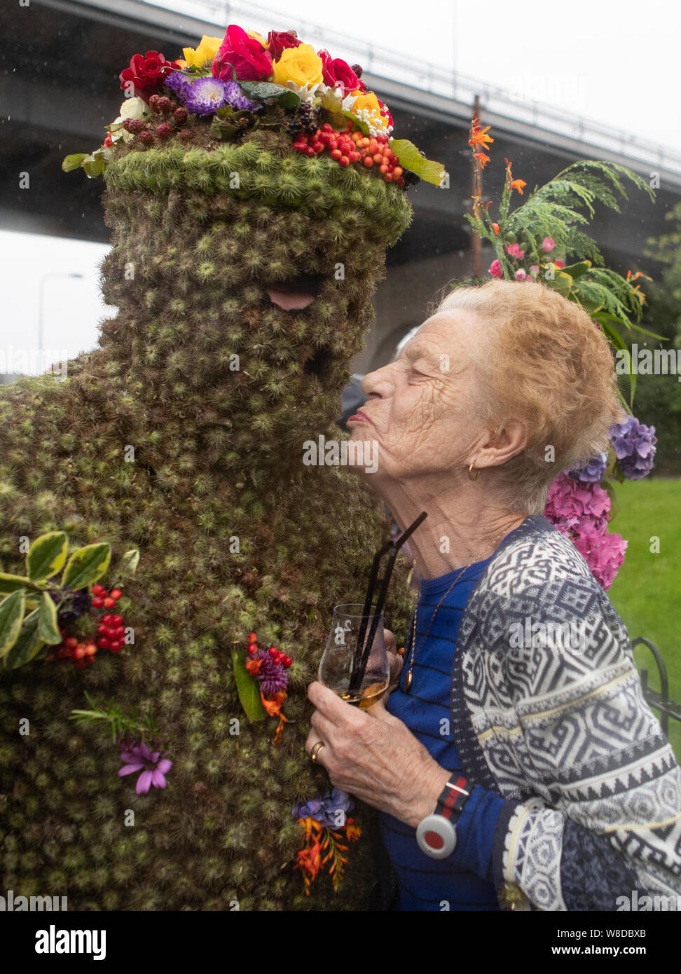 Burryman Andrew Taylor, gets a kiss and a nip of whisky using a straw ...
