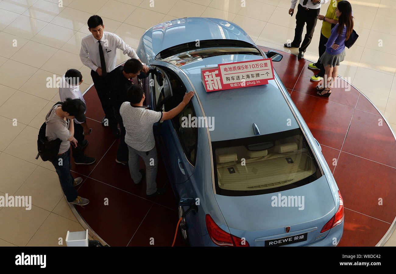 Chinese car buyers look at a Roewe 550 Hybrid car of SAIC Motor on ...