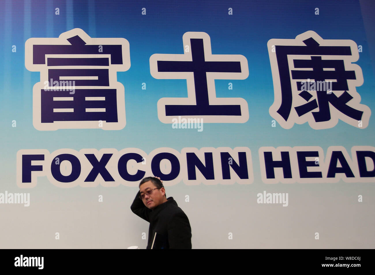 --FILE--A pedestrian walks past a signboard of the Foxconn headquarters ...