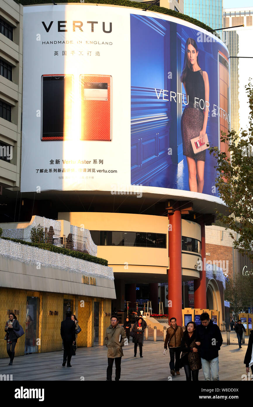 --FILE--Pedestrians walk past an advertisement for Vertu luxury ...