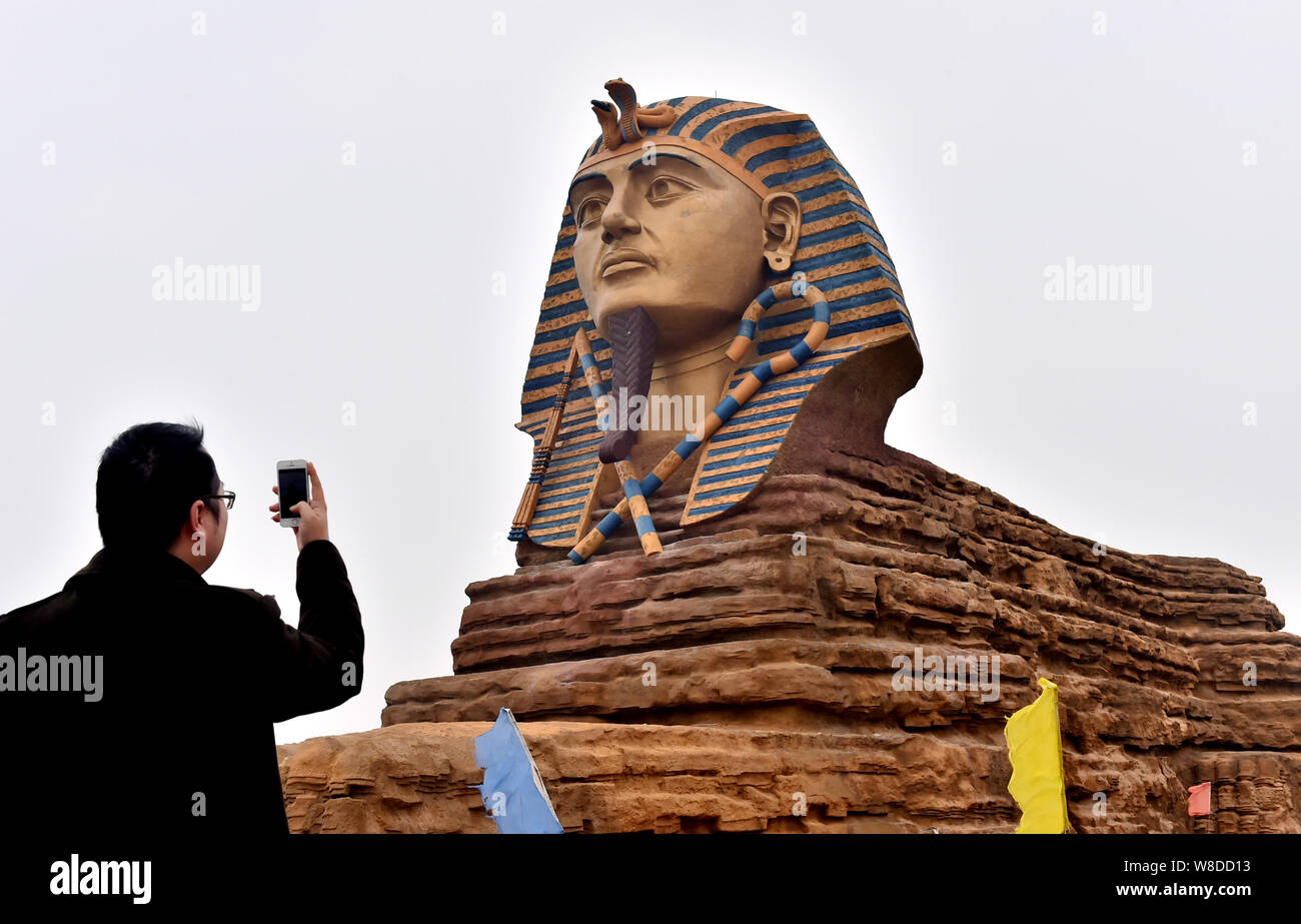 A visitor takes photos of a replica of the Sphinx at a World Cultural ...