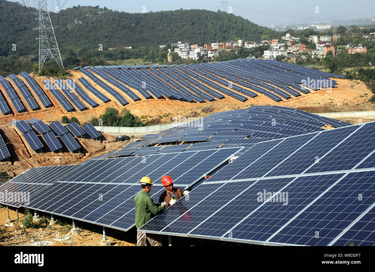 --FILE--Chinese workers install solar panels at a photovoltaic power ...