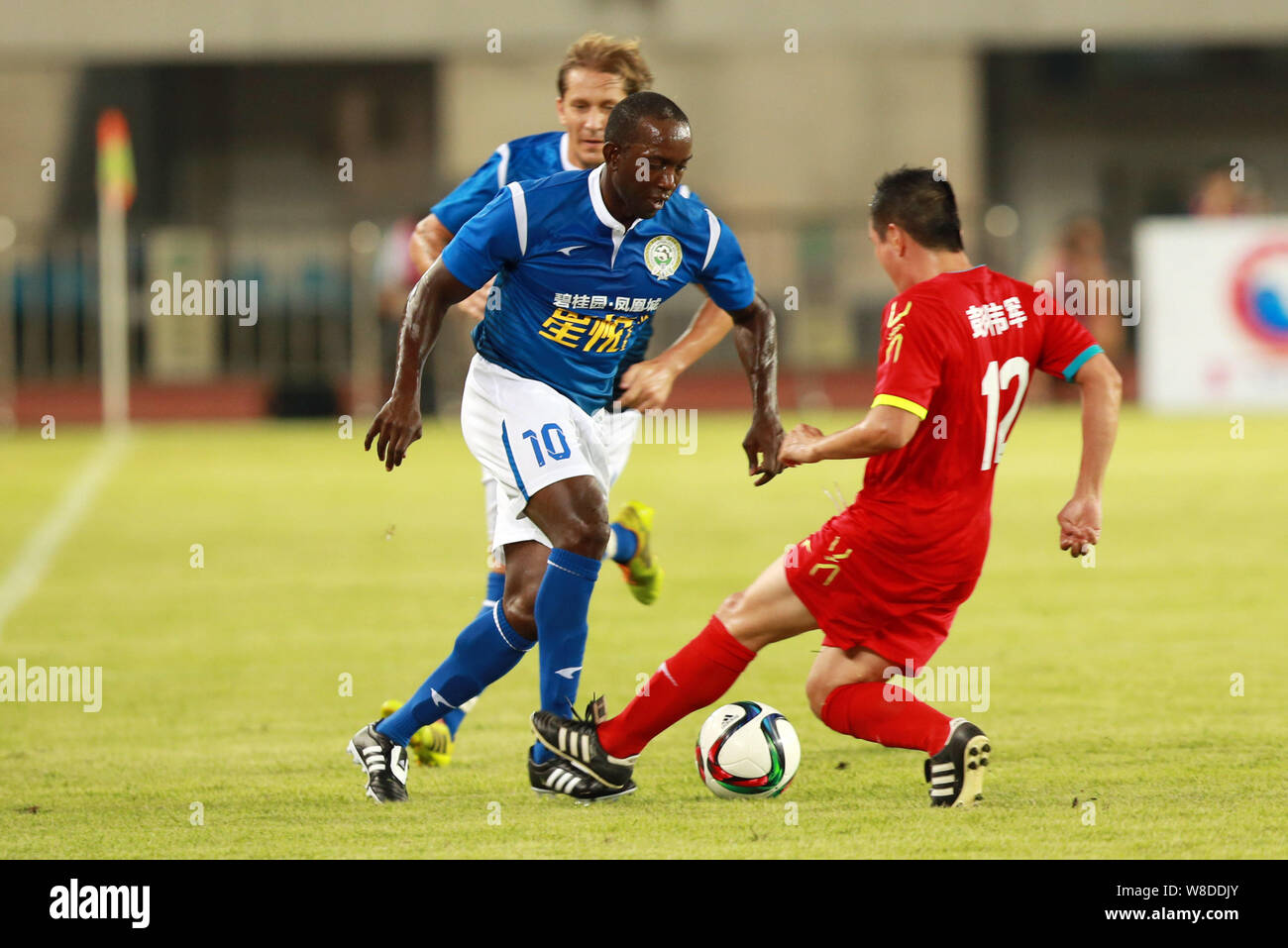 Dwight Yorke of the European Legends Team, left, challenges Peng Weijun of the Chinese Legends ...