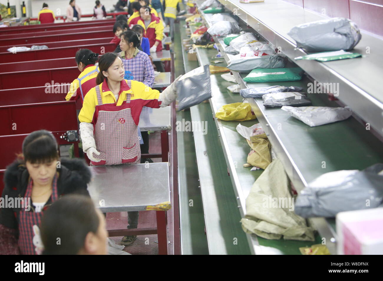 Chinese workers sort parcels, most of which are from online shopping ...