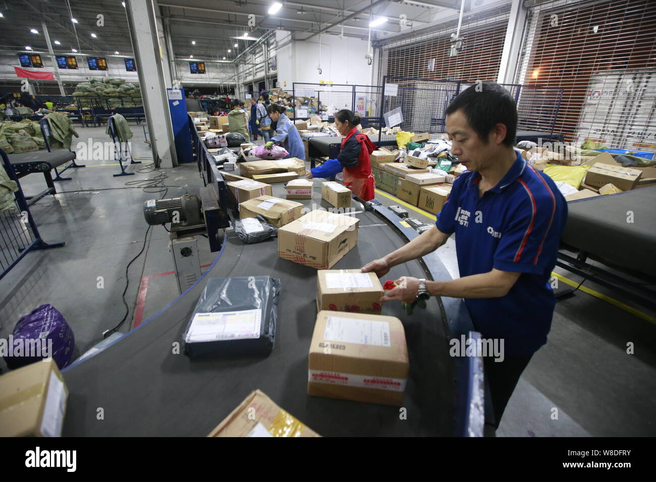 Chinese workers sort parcels, most of which are from online shopping ...