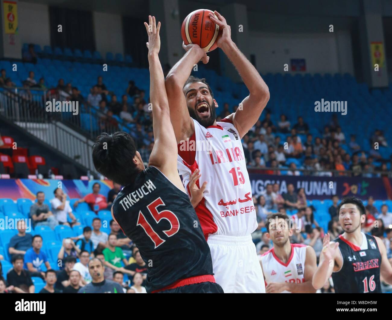 Joji Takeuchi of Japan, right, challenges Hamed Ehadadi of Iran in the ...