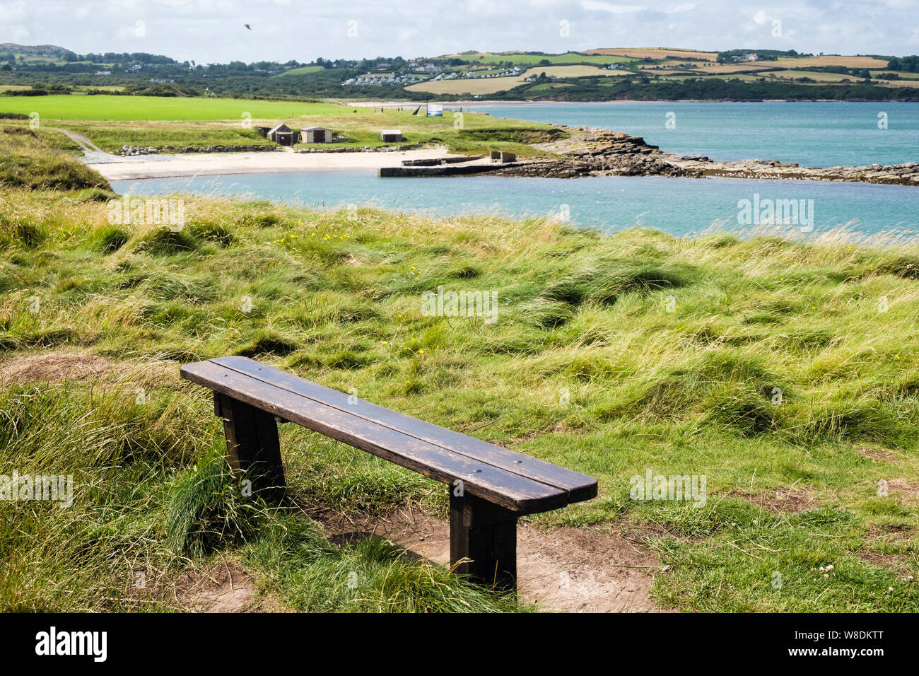 Empty bench on Wales Coastal Path overlooking Lligwy Bay. Moelfre, Isle ...