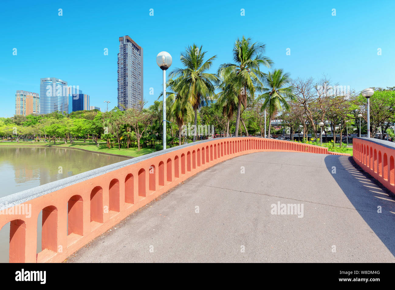 Pathway through green trees at public park Stock Photo - Alamy